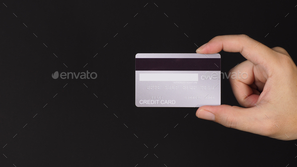 Hand is show back of silver credit card isolated on white background ...