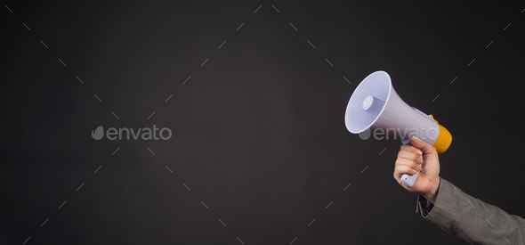 Hand is hold megaphone and wear grey suit on black background. Stock ...