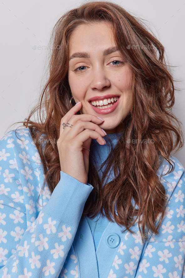 Positive long haired woman smiles toothily has healthy clean skin white ...