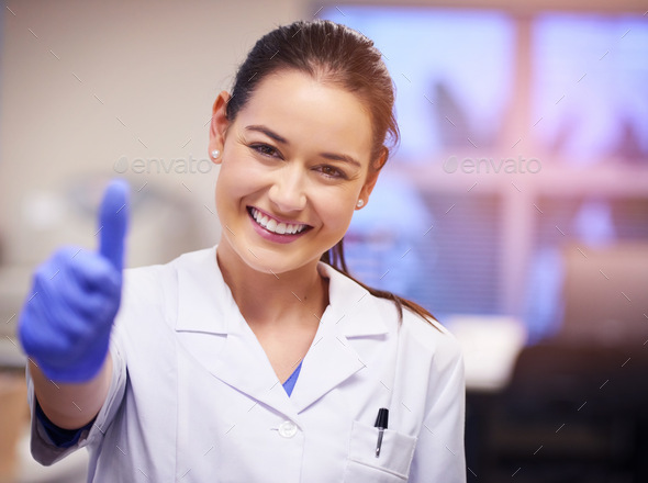 Portrait of a confident young scientist showing a thumbs up gesture in ...