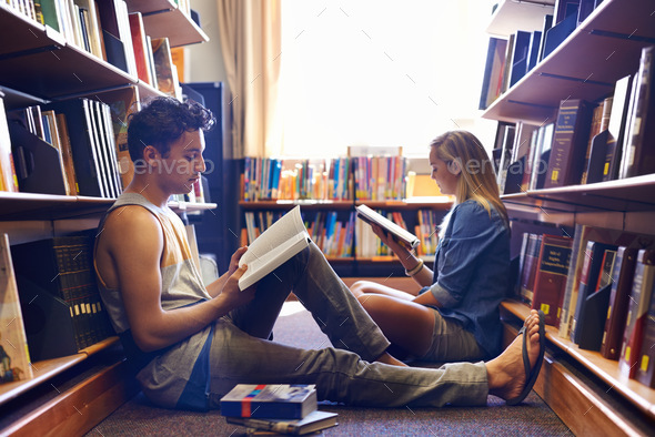 Studying together, but separately. Two students reading separate ...