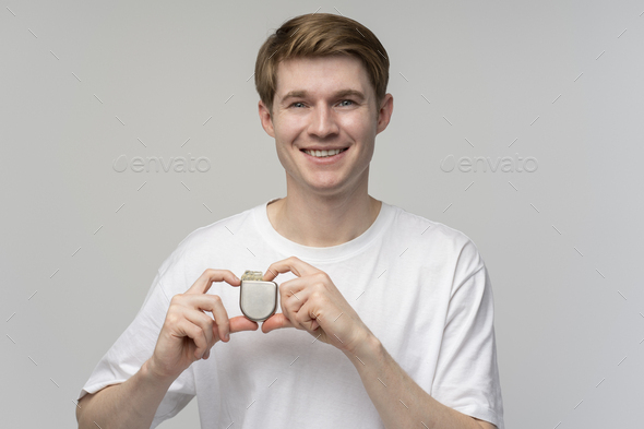 Caucasian man holding Implantable cardioverter defibrillator (ICDs) and ...