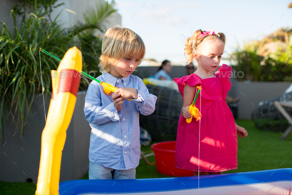 Brother and sister playing fishing in the kiddie pool Stock Photo by ...