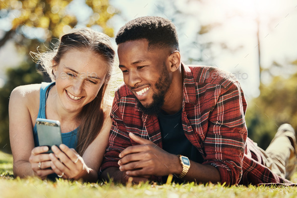 Interracial, couple and phone social media in park to relax, bond and ...