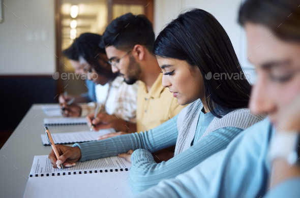 Students, writing exam and studying in classroom for education ...