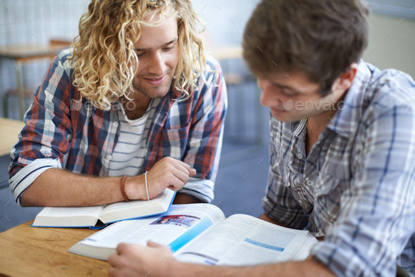 Study partners. Shot of two male students studying together in class ...