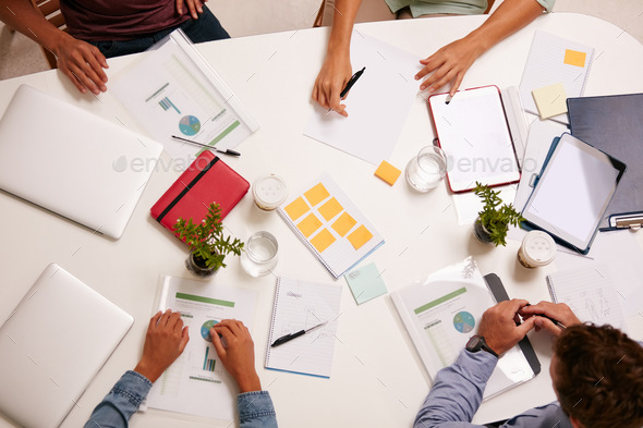 High angle shot of a group of businesspeople working together around a ...