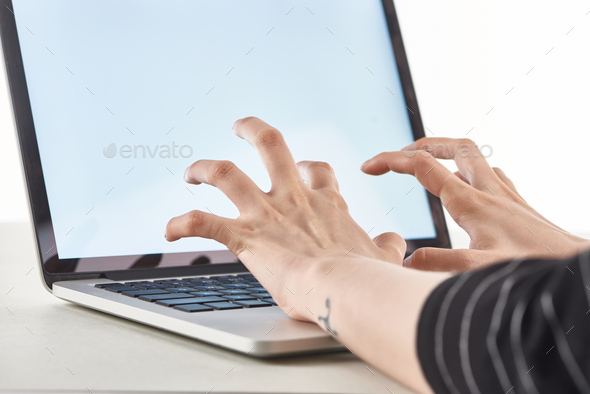 cropped view of angry girl typing on laptop keyboard isolated on white ...