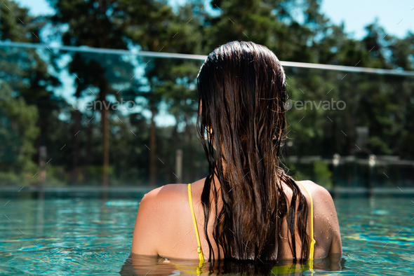 Back view of woman in swimming in pool on resort during daytime Stock ...