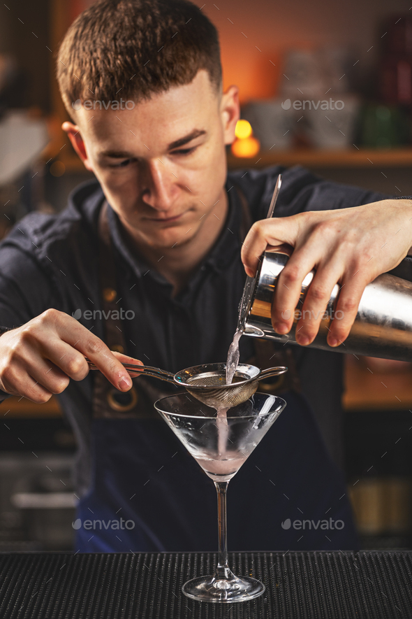 Barman preparing and pouring pink cocktail Stock Photo by grafvision