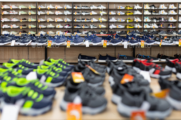 large shoe store with long shelves filled with shoes Stock Photo by ...