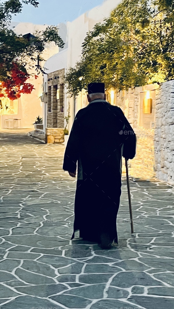 Silhouette of Greek Orthodox priest with cane as he walks away from ...