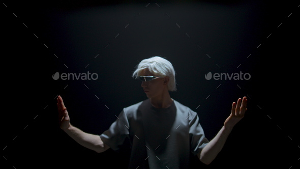 Man using virtual simulation goggles in dark room. Futuristic player ...