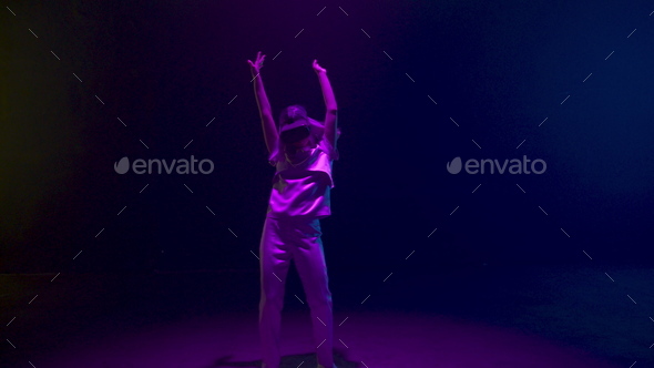 Neon gamer dancing headset in dark cyberspace. Futuristic woman ...