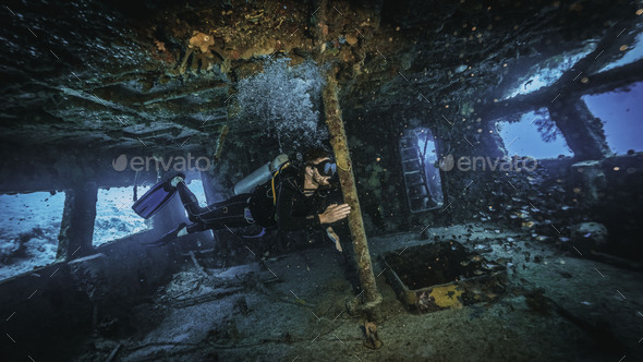 scuba diver exploring inside a military shipwreck Stock Photo by ...