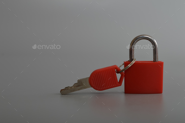 red padlock and key isolated on a grey background. Copy space for the ...