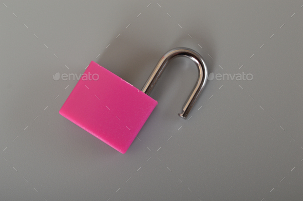 An opened pink padlock isolated on a grey background. Copy space for ...