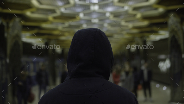Rear view of a single hooded man in the subway. Concept of loneliness ...