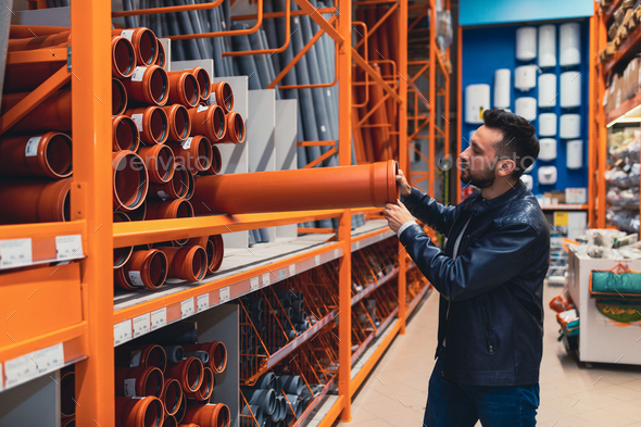 man chooses sewer pipes hardware stores to build a new house. Stock ...