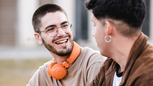 Two cool friends talking and laughing together siting outdoors Stock ...