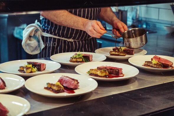 The hands of the chef preparing a fine dinner in the kitchen of a ...