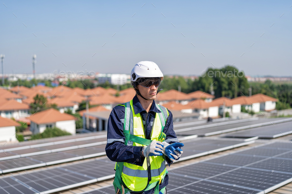 Engineer on rooftop stand next to solar panels wear safety gear wear ...
