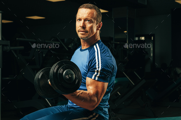 Fit senior man exercising with dumbbells in a gym Stock Photo by ...