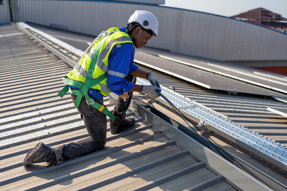 Engineer on rooftop knee down check cable pulling for solar panels ...