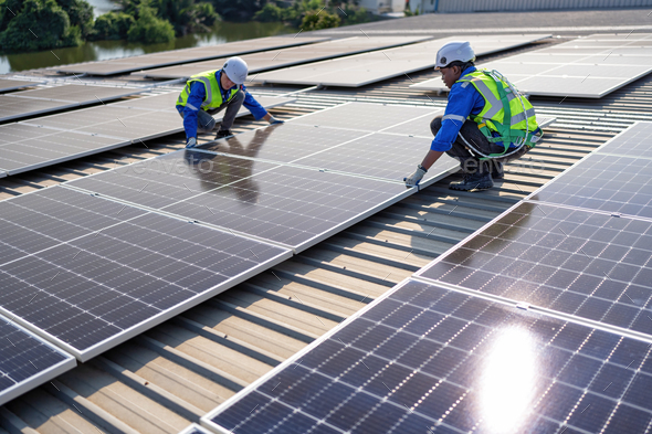 Engineer on rooftop standing next to solar panels photo voltaic check ...