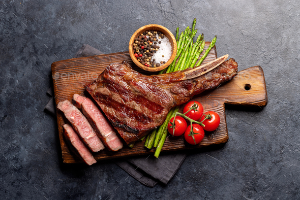 Medium rare grilled Tomahawk beef steak with asparagus Stock Photo by ...