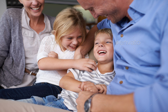 Feeling so loved by his family. A happy little boy laughing while ...