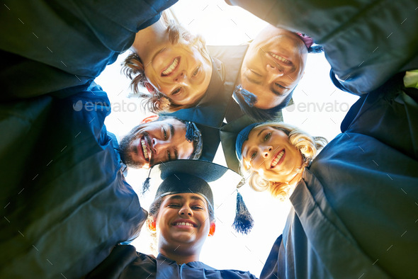 Portrait of a group of students standing in a huddle with their heads ...