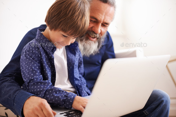 Learning with grandpa. Shot of a grandfather and grandson using a ...