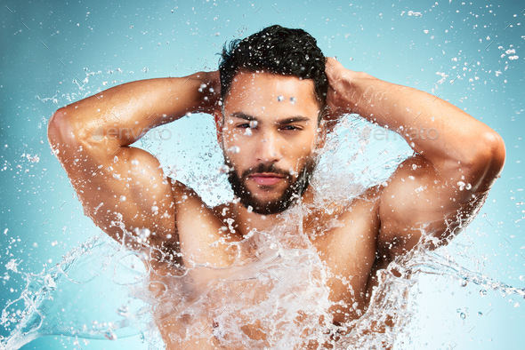 Water, splash and man washing his body on a blue studio background for ...