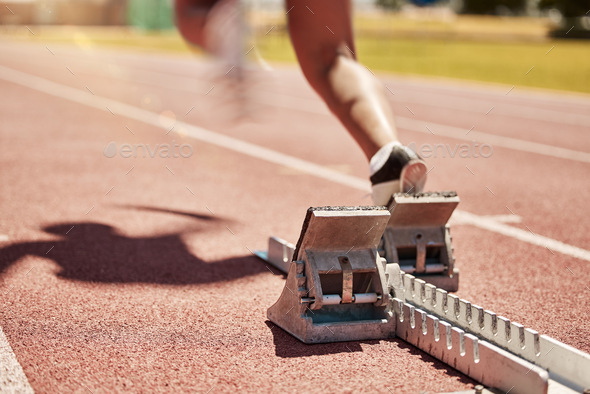 Sports, fitness and running with a starting block on a track for a ...