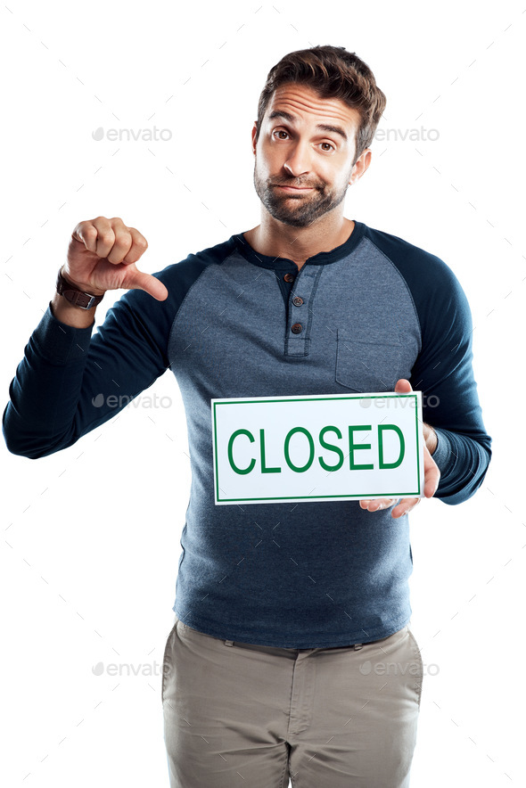 Studio portrait of a handsome young man holding a closed sign against a ...