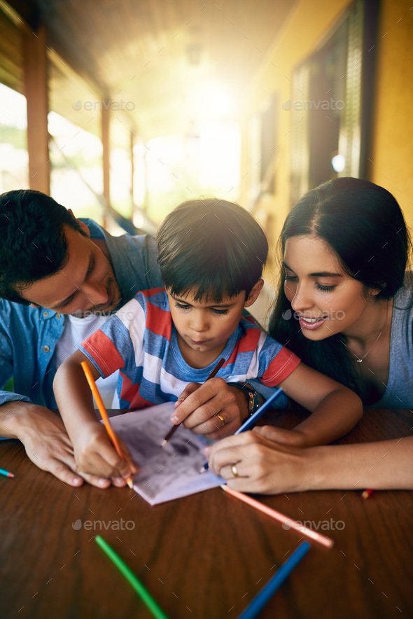 Cropped shot of young affectionate parents colouring in pictures with ...