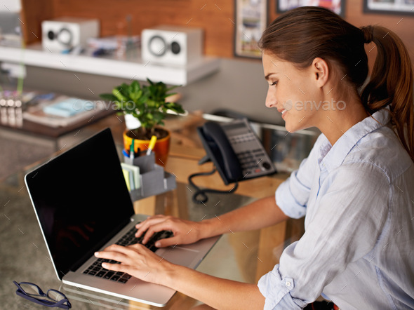 Getting some work done after hours. An attractive young woman working ...