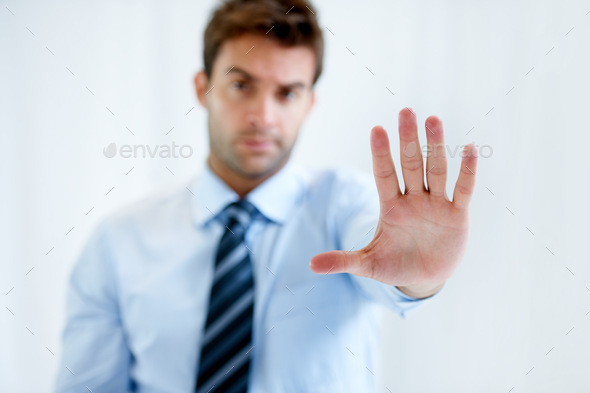 Portrait of a businessman with a stern expression and holding up his ...