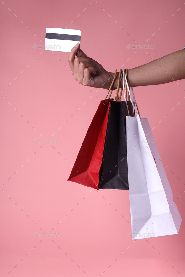 Hand holding shopping bags and credit card Stock Photo by Queenmoonlite35