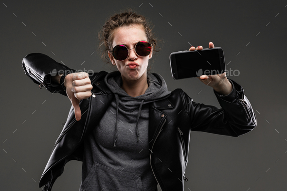 Stubborn caucasian girl with rough facial features in a black jacket ...