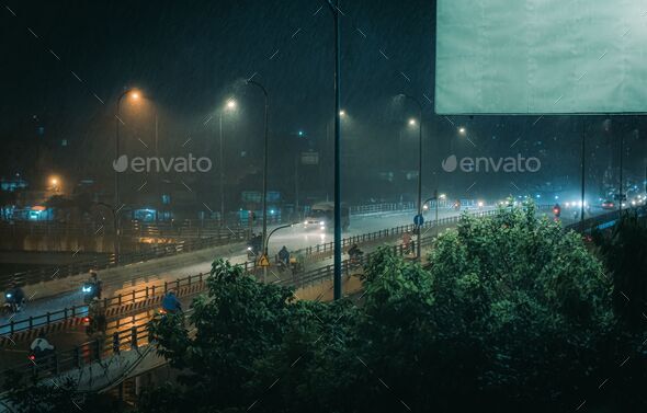 High angle of a night rainy street view with lights and trees around ...
