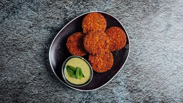 Top view of golden chicken kebabs with a mint sauce served on a round ...