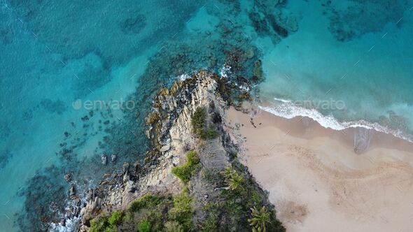 Aerial top view of the sandy beach with trees and a turquoise ocean on ...