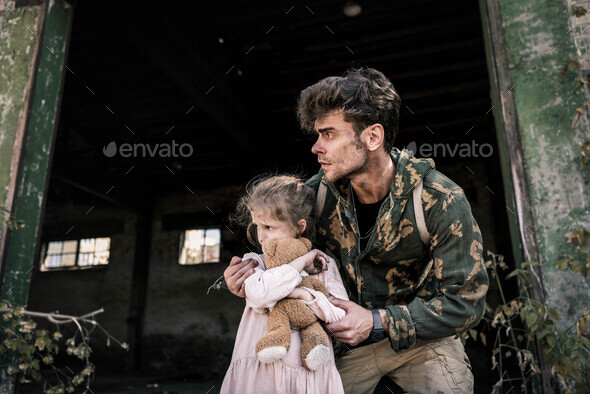 handsome man standing with cute child outside, post apocalyptic concept ...