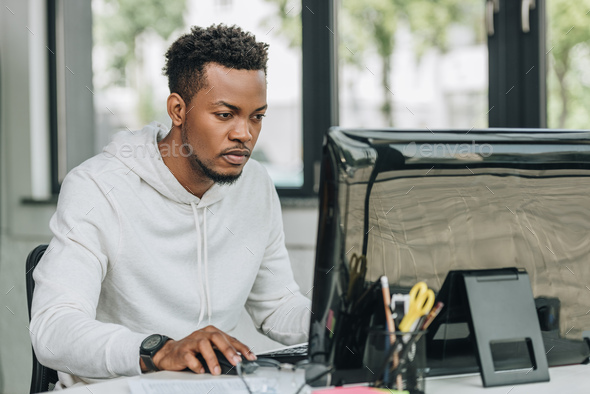 attentive african american programmer working on computer in office ...