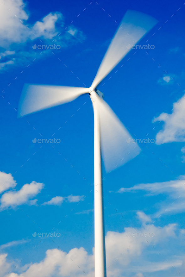 Fast spinning wind turbine blue sky generating electricity Stock Photo ...