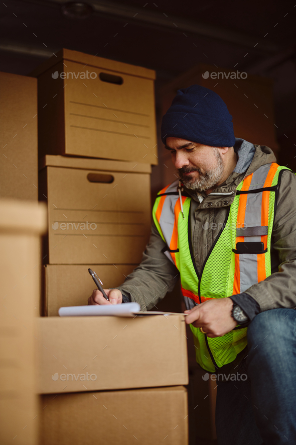 Truck driver filling delivery paperwork before the shipment. Stock ...