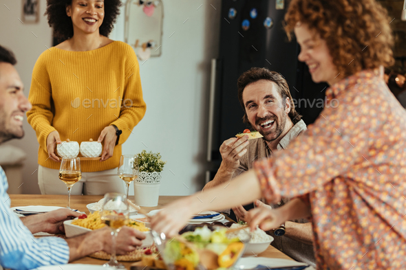 Happy man eating and having fun with his friends during lunch at dining ...