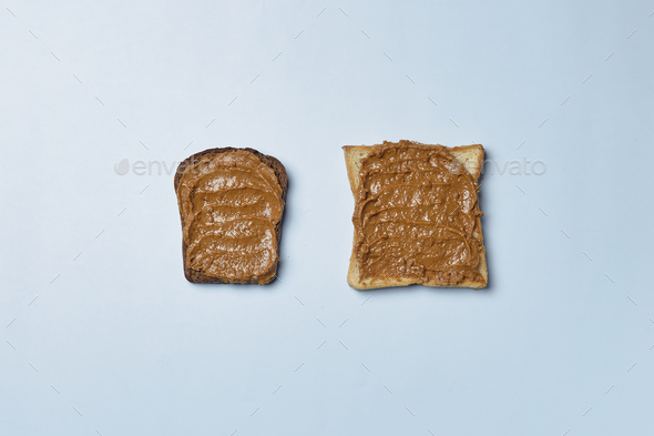 Slice of brown bread and a toast buttered with tasty peanut butter over ...